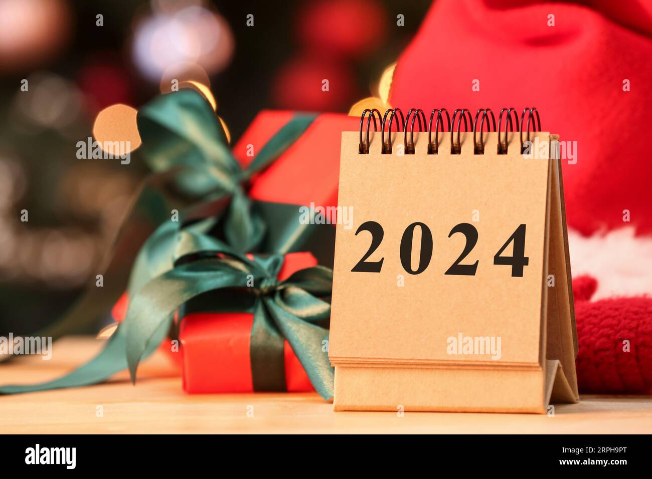 Calendar with figure 2024 and Christmas gifts on table Stock Photo - Alamy