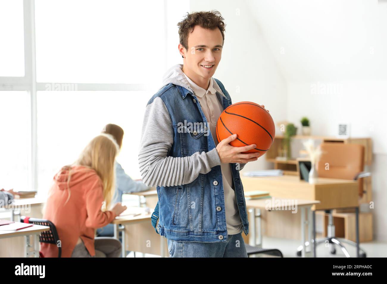 Male student with ball in classroom Stock Photo - Alamy