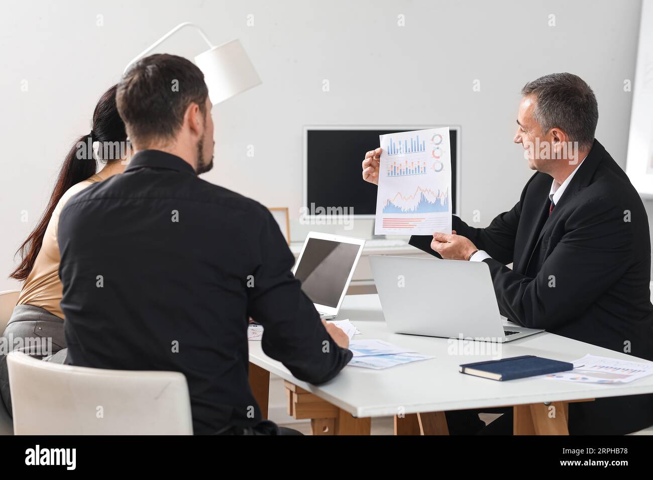 Business consultants working with diagrams at table in office Stock ...