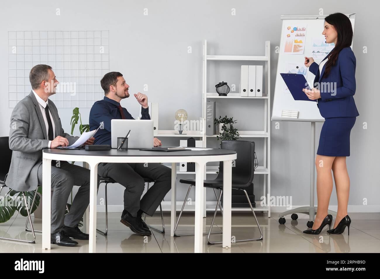 Female business consultant giving presentation to her colleagues in ...