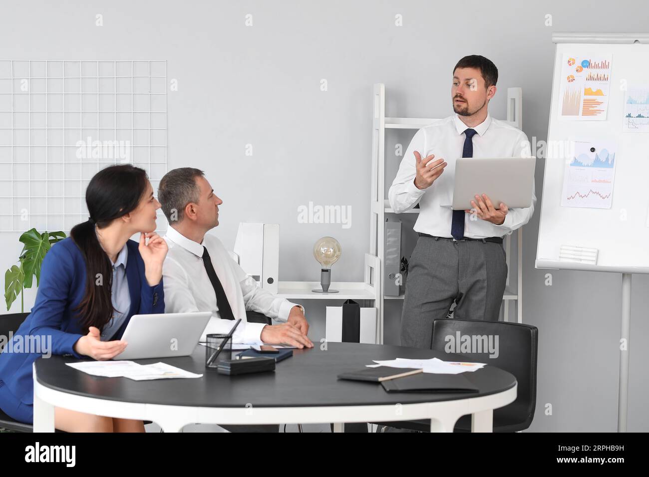 Male business consultant giving presentation to his colleagues in ...