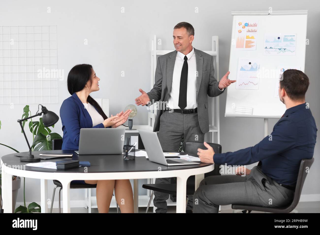Male business consultant giving presentation to his colleagues in ...