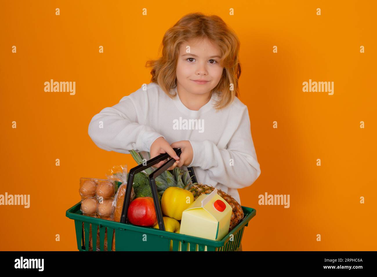 Grocery shop. Portrait of child with shopping basket purchasing food in ...