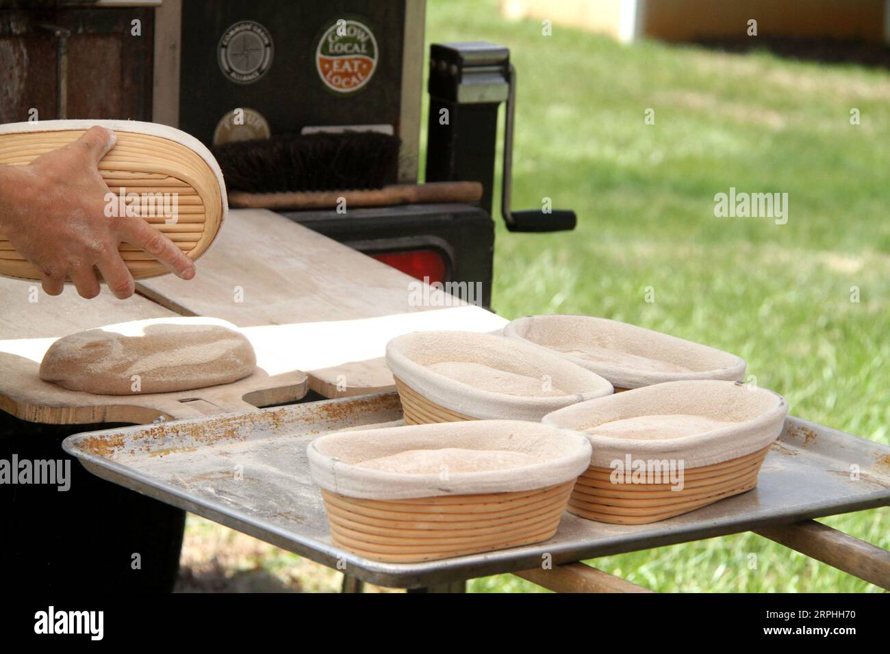 Baker taking the bread loaves out of the proofing baskets before ...
