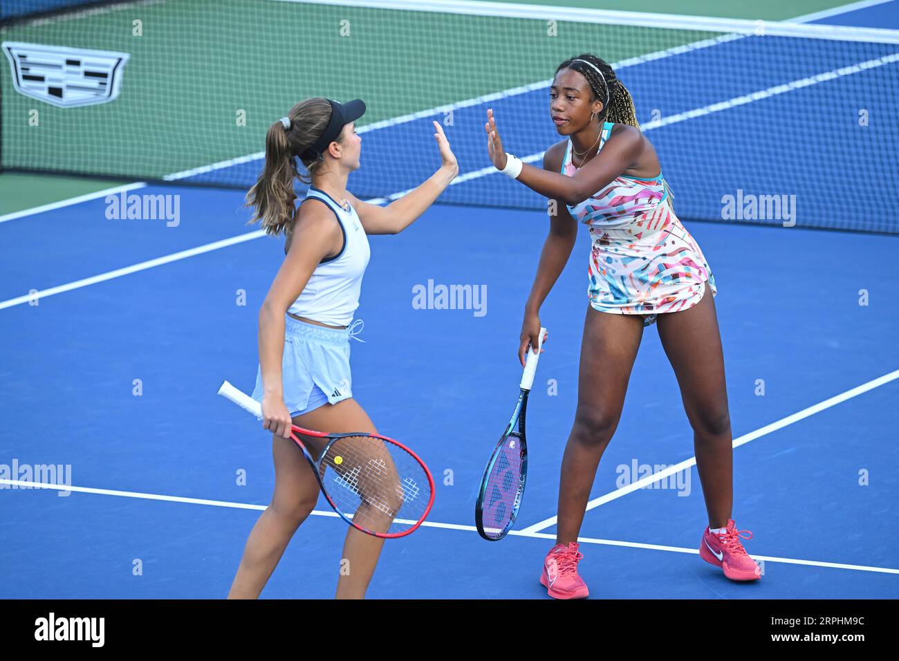 Iva Jovic high fives Tyra Caterina Grant during a junior girls' doubles match at the 2023 US ...