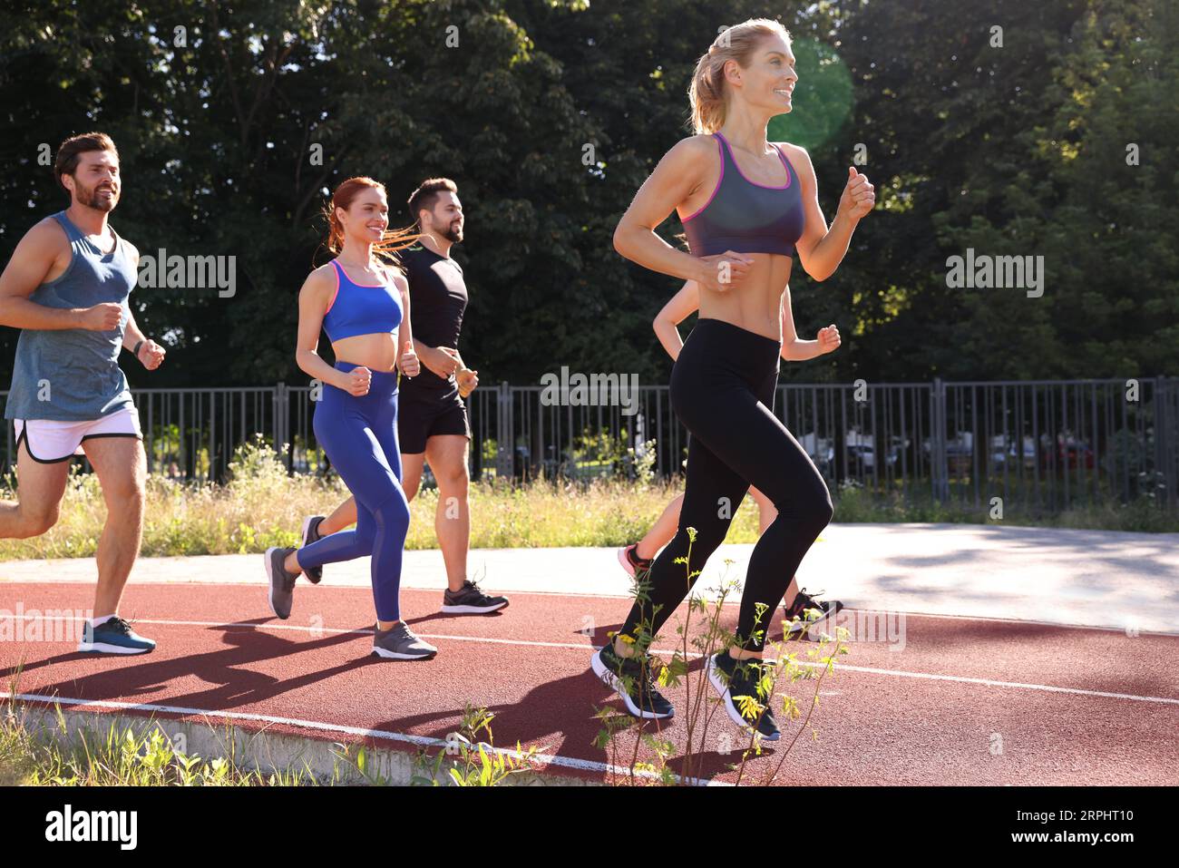 Group of people running at stadium on sunny day Stock Photo - Alamy