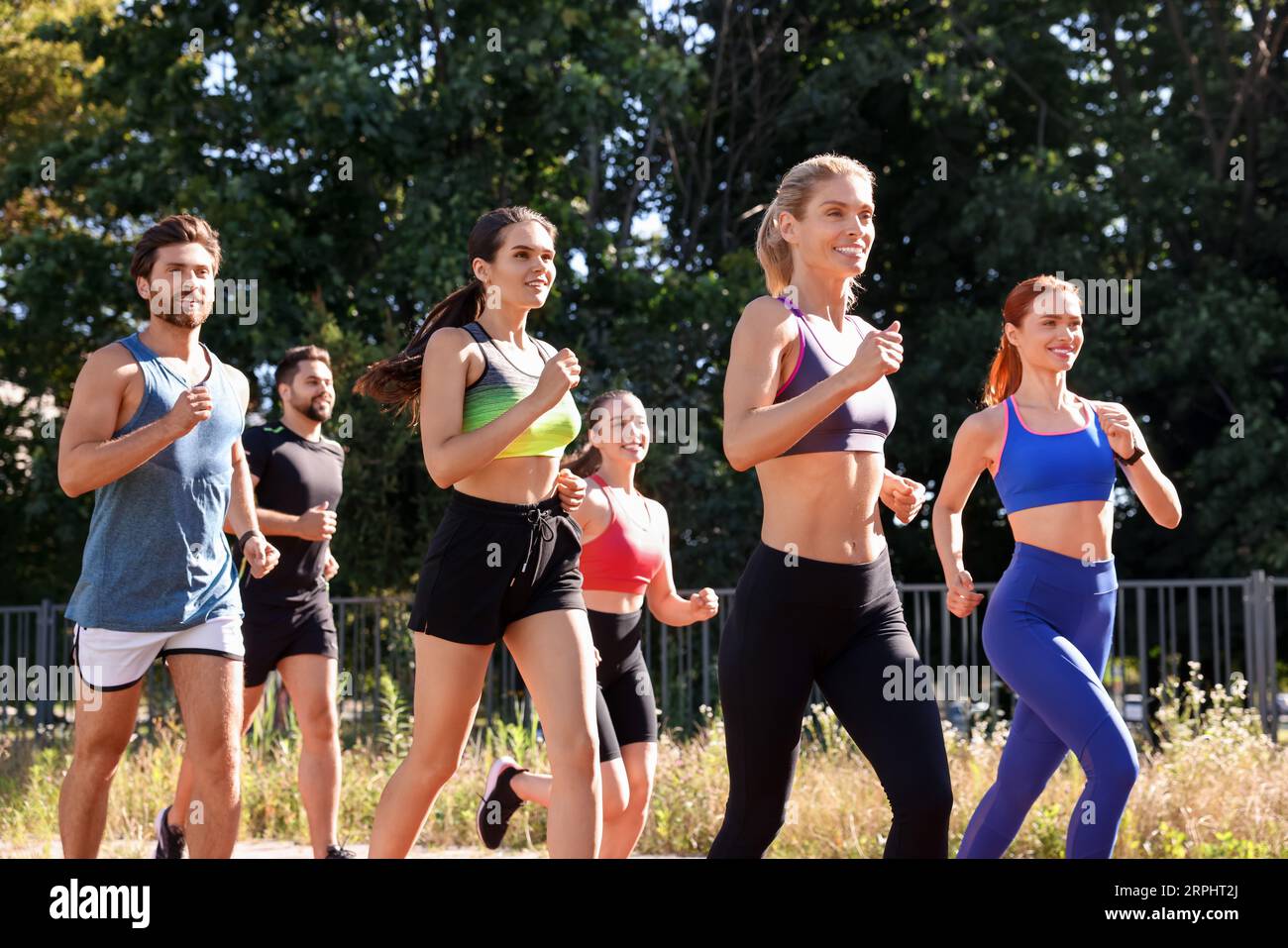 Group of people running outdoors on sunny day Stock Photo - Alamy