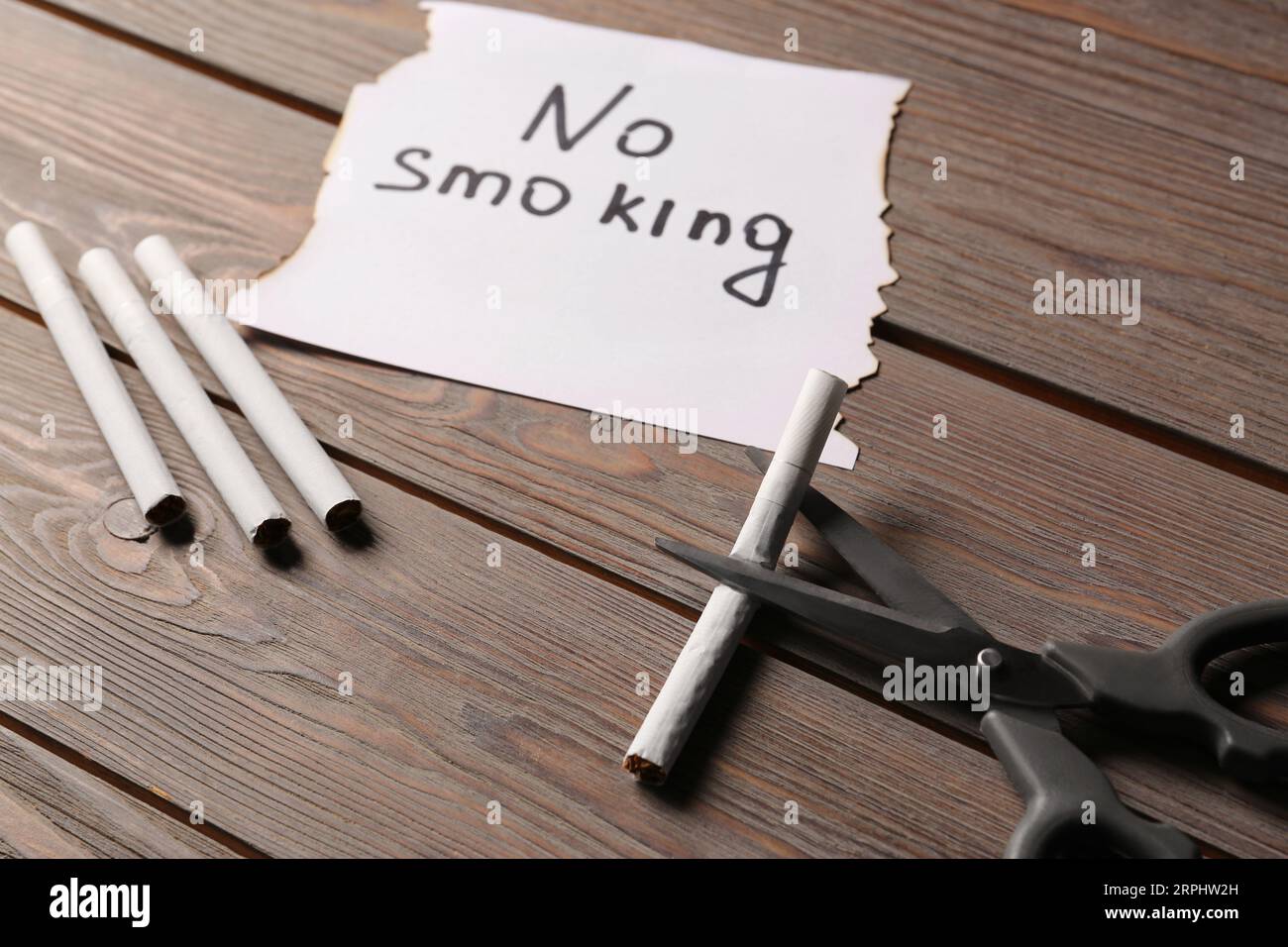 Words No Smoking written on paper and scissors cutting cigarette on ...