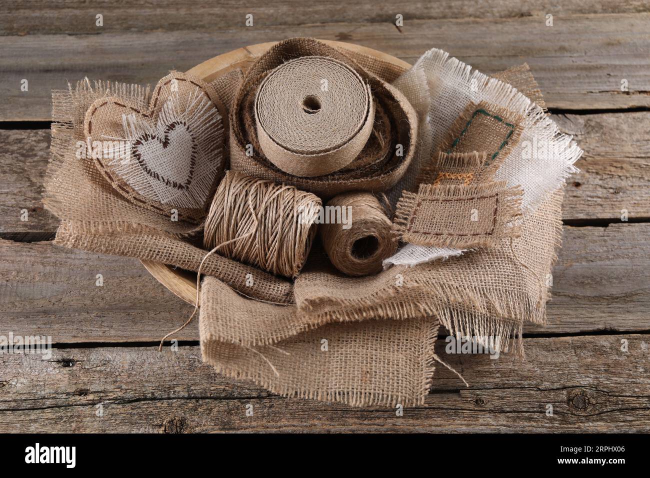Pieces of burlap fabric and spools of twine on wooden table, above view ...