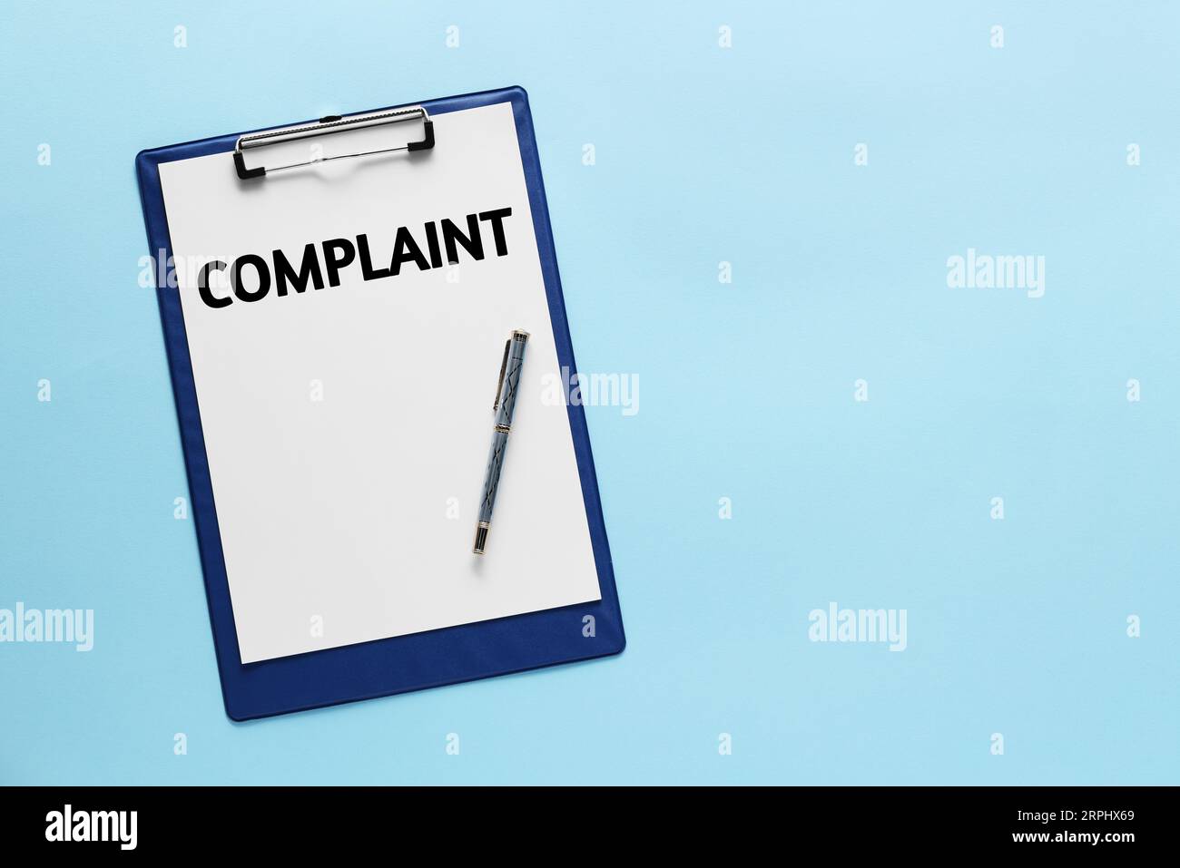 Paper with word Complaints attached to clipboard on light blue ...