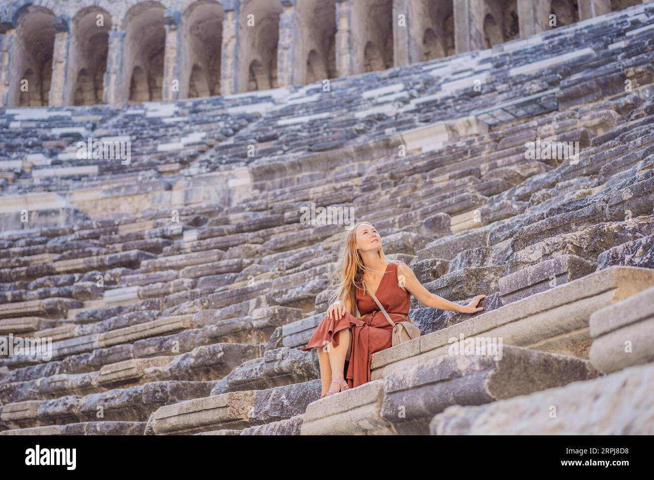 Woman tourist explores Aspendos Ancient City. Aspendos acropolis city ...