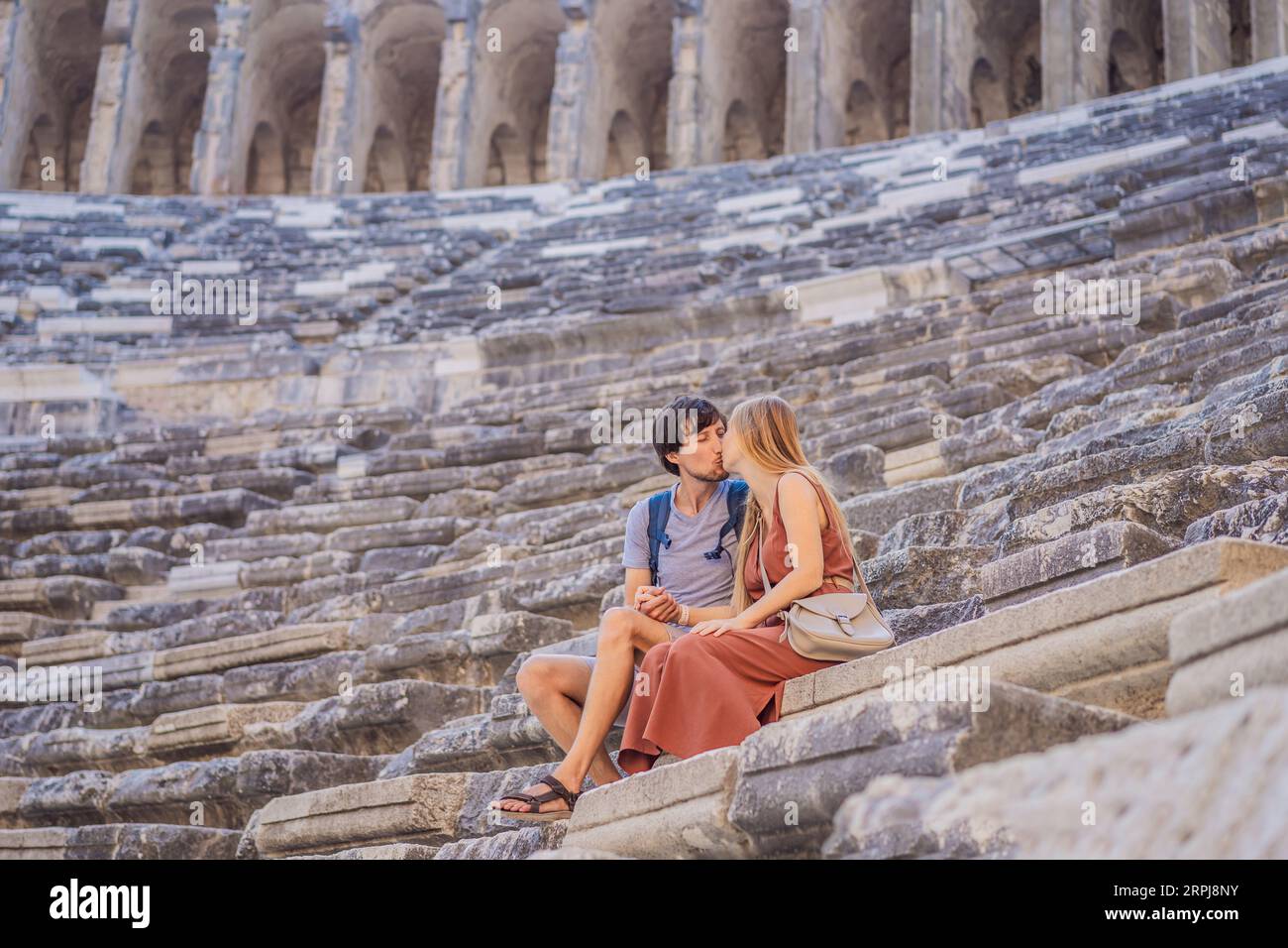 Happy couple man and woman tourists explores Aspendos Ancient City ...