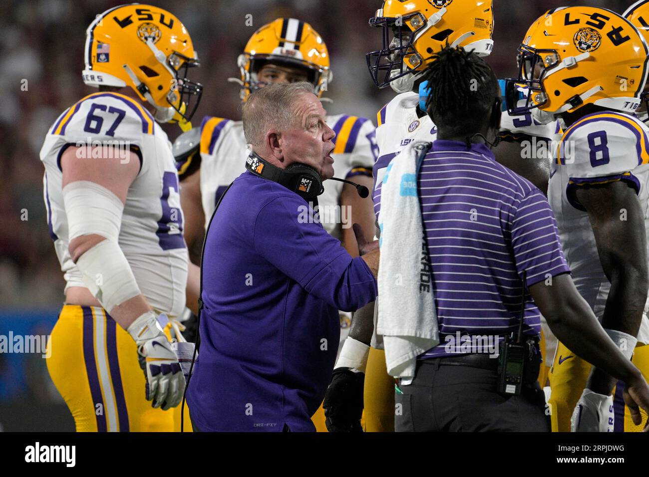 LSU head coach Brian Kelly, center, huddles with players on the field ...