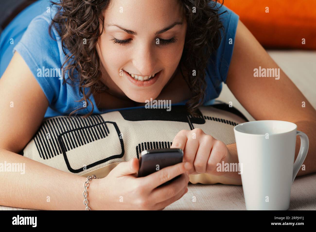 curly-haired lady lies comfortably on floor cushions at home, deeply ...