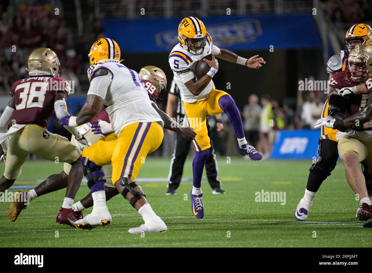 LSU quarterback Jayden Daniels (5) hurdles over Florida State defensive ...