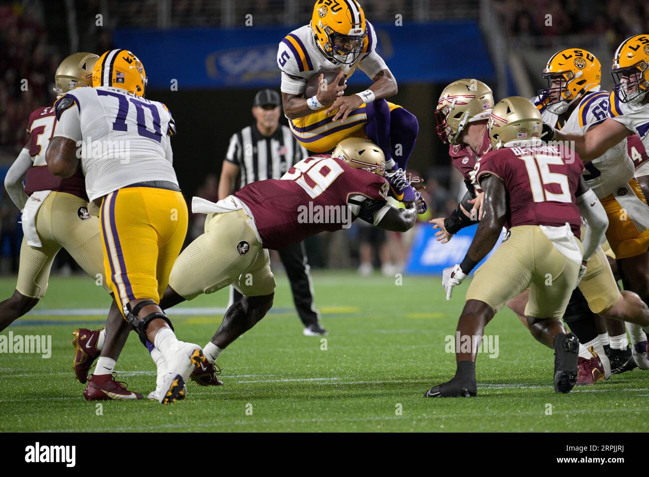 LSU quarterback Jayden Daniels (5) hurdles over Florida State defensive ...