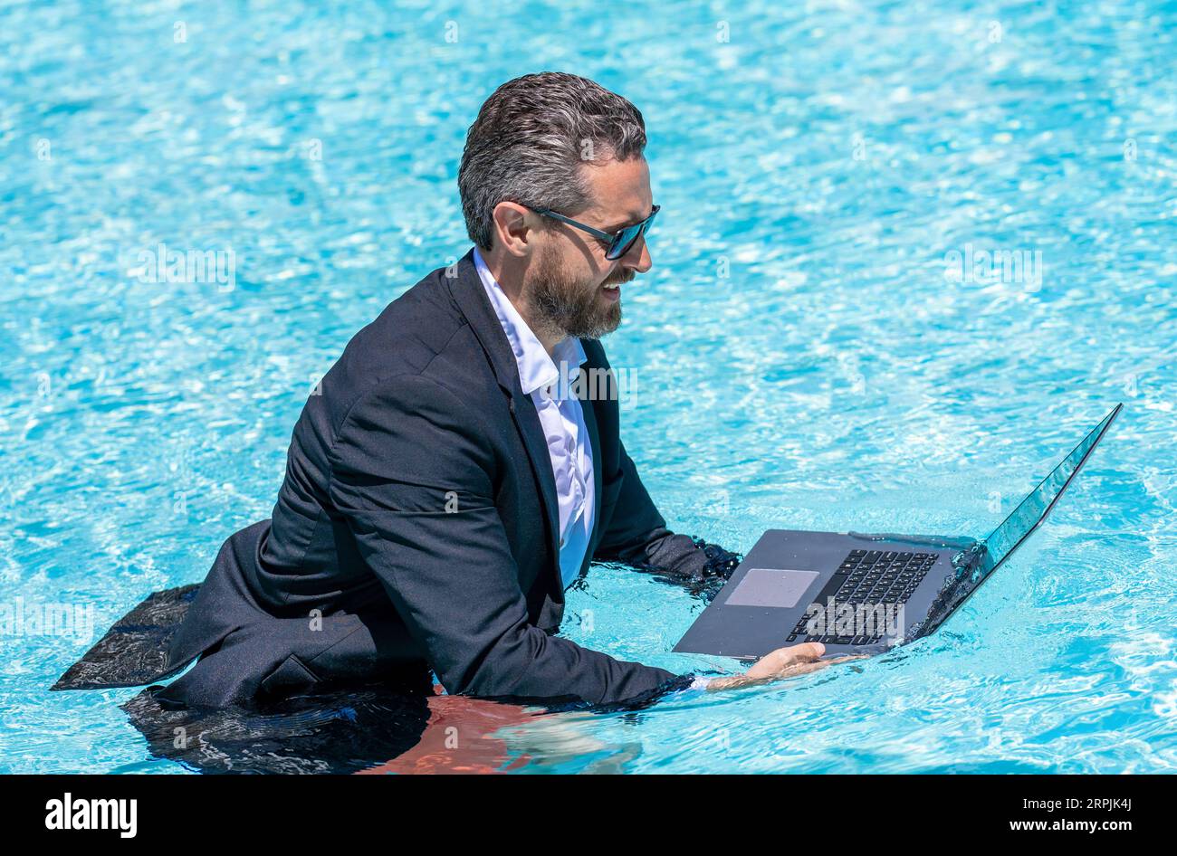 Businessman in suit with laptop in swimming pool. business man on ...