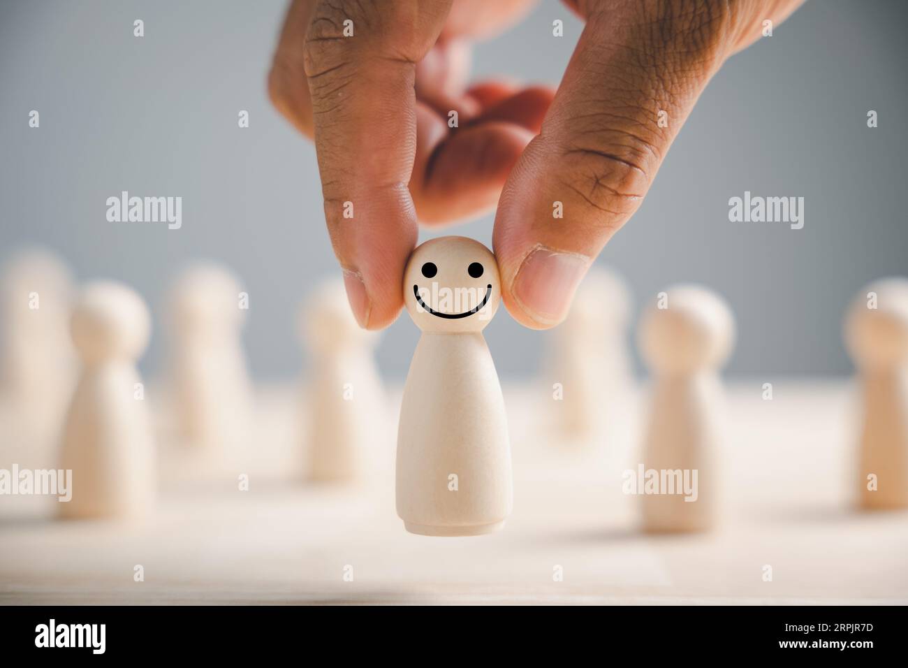 Hand choosing a wooden figure as the chosen leader from the crowd Stock ...