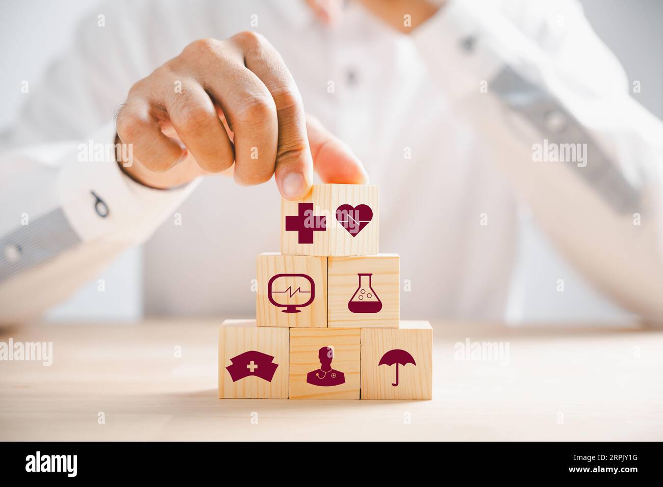 Hand hold wooden block with icon healthcare medical Stock Photo - Alamy