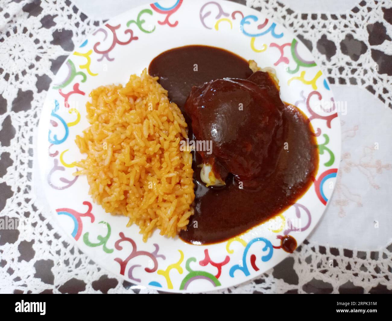 Typical Mexican Dish Red Mole On A Piece Of Chicken With Red Rice