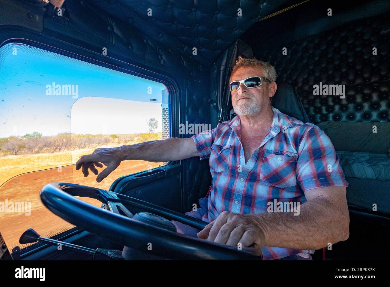 Long distance heavy haulage B-double truck driver at the wheel of his ...
