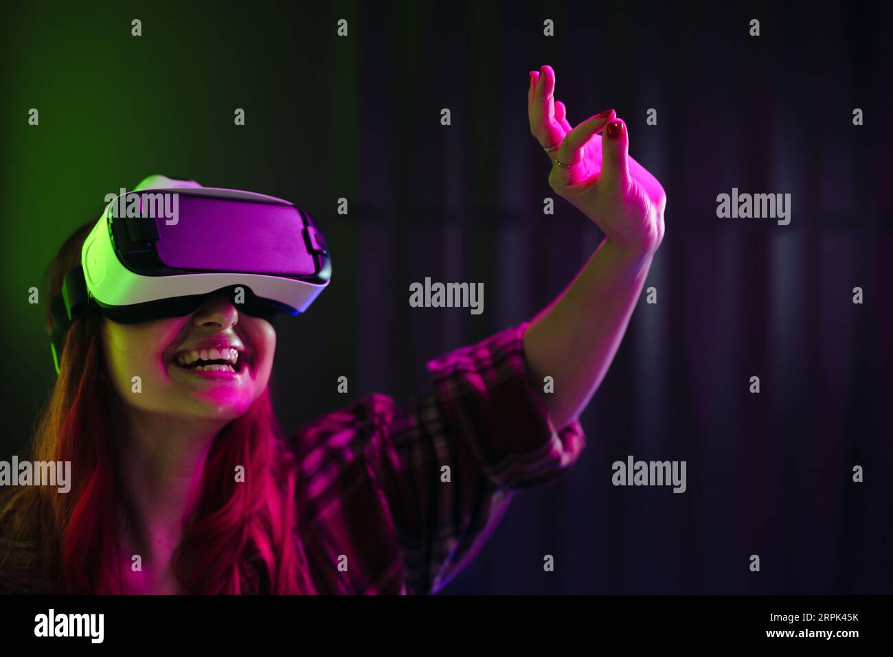 Woman smiling as she engages with the exciting world of virtual reality ...
