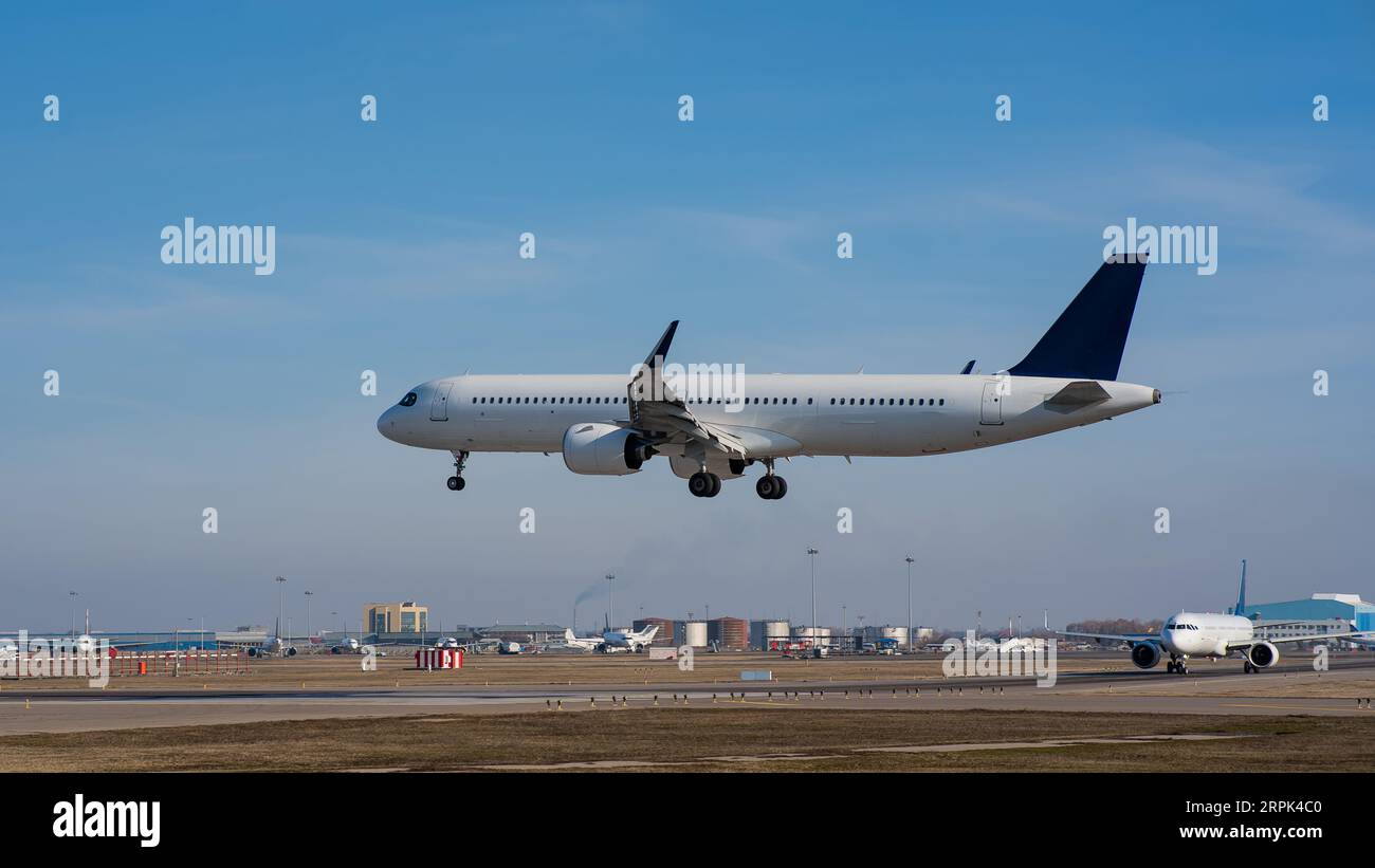 Side view of an airplane landing against a blue sky. Widescreen Stock ...