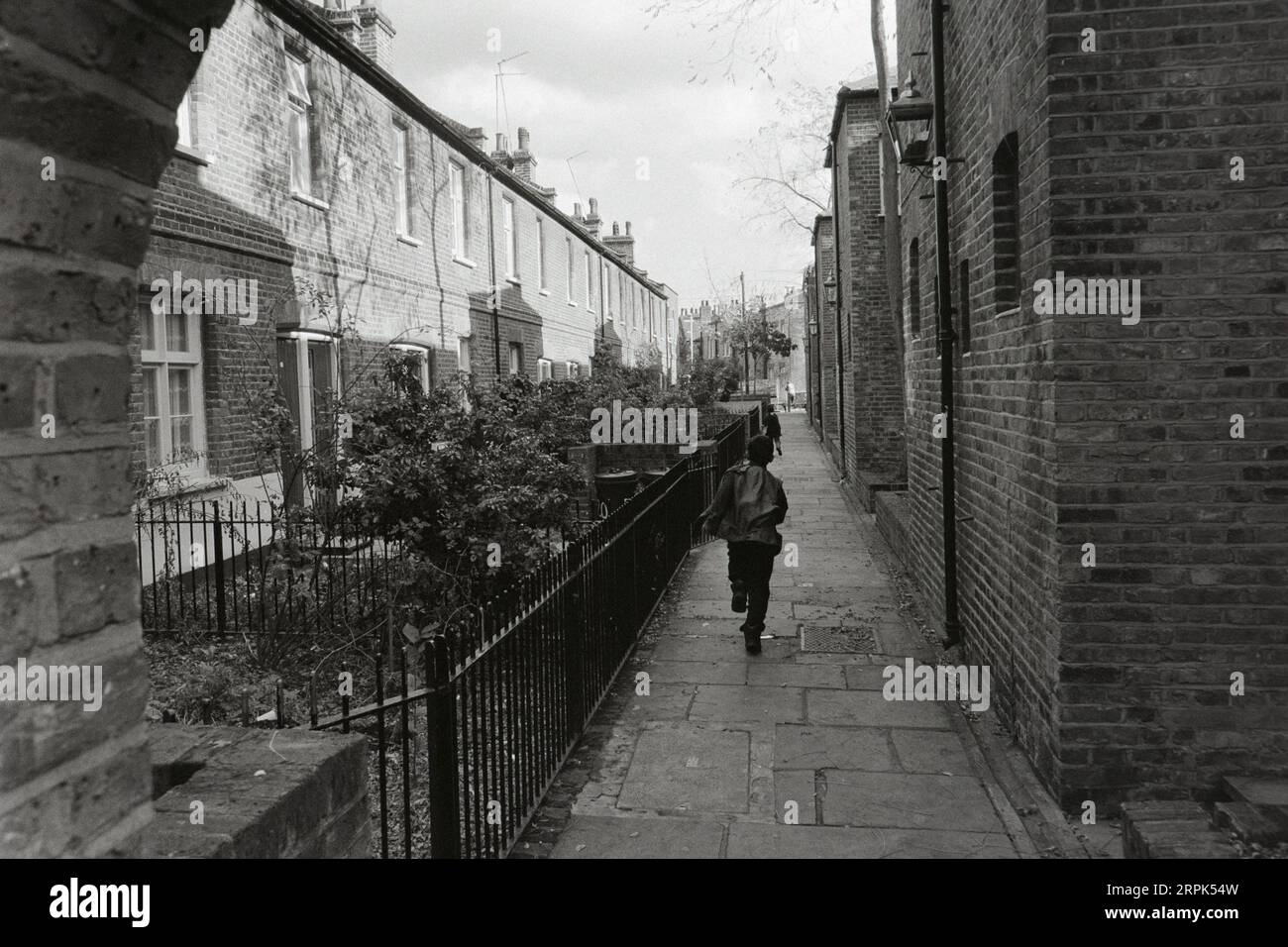 Man walking down a back alley in East London Stock Photo - Alamy