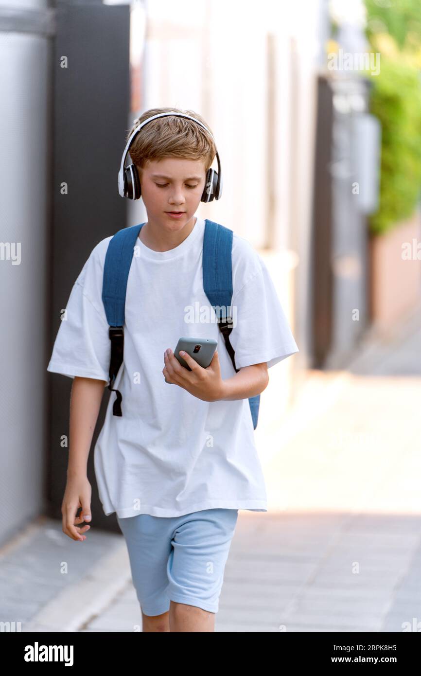 Boy using phone with headset on street hi-res stock photography and ...