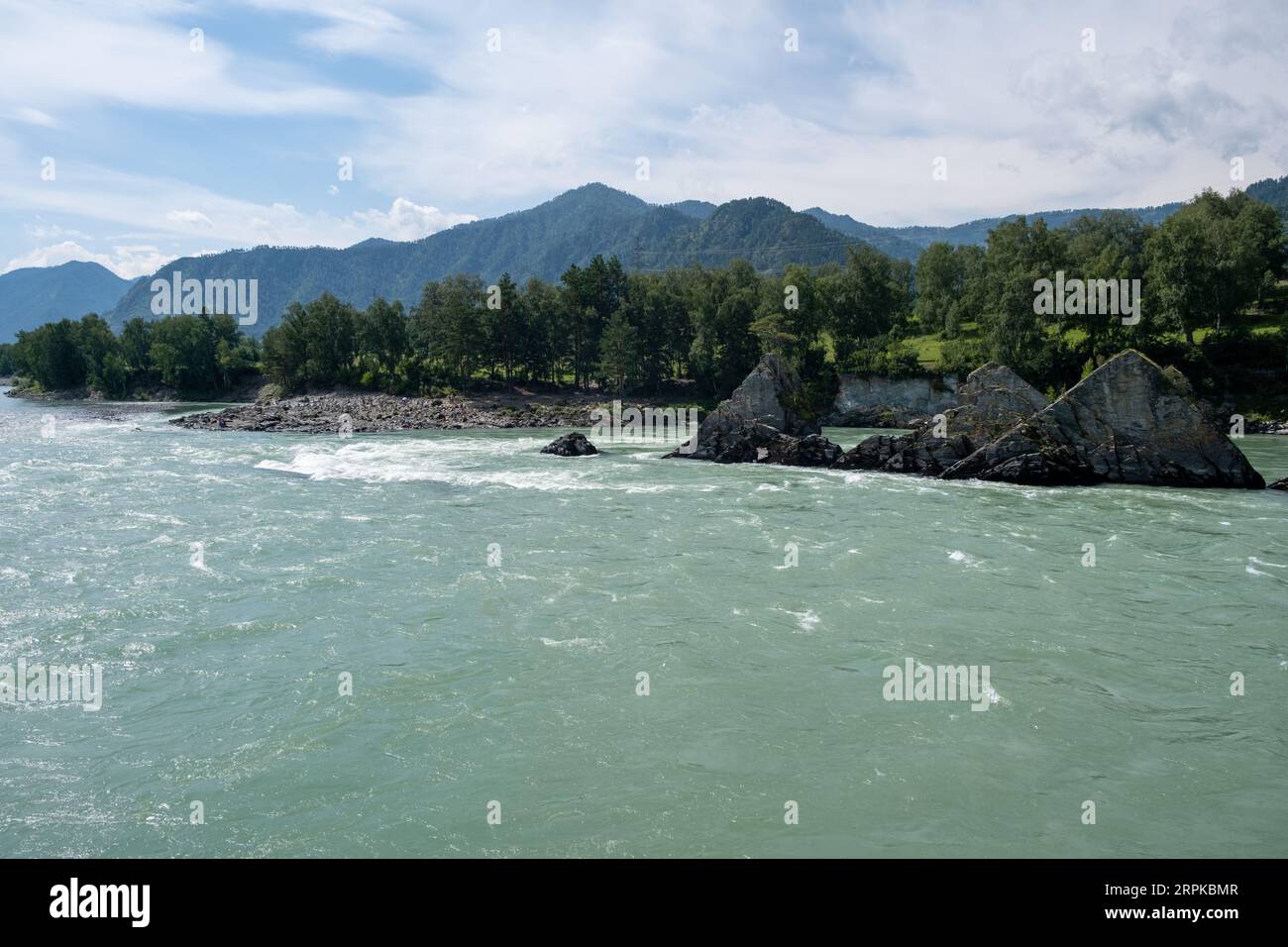 A wide, full-flowing mountain river with a fast current Stock Photo - Alamy