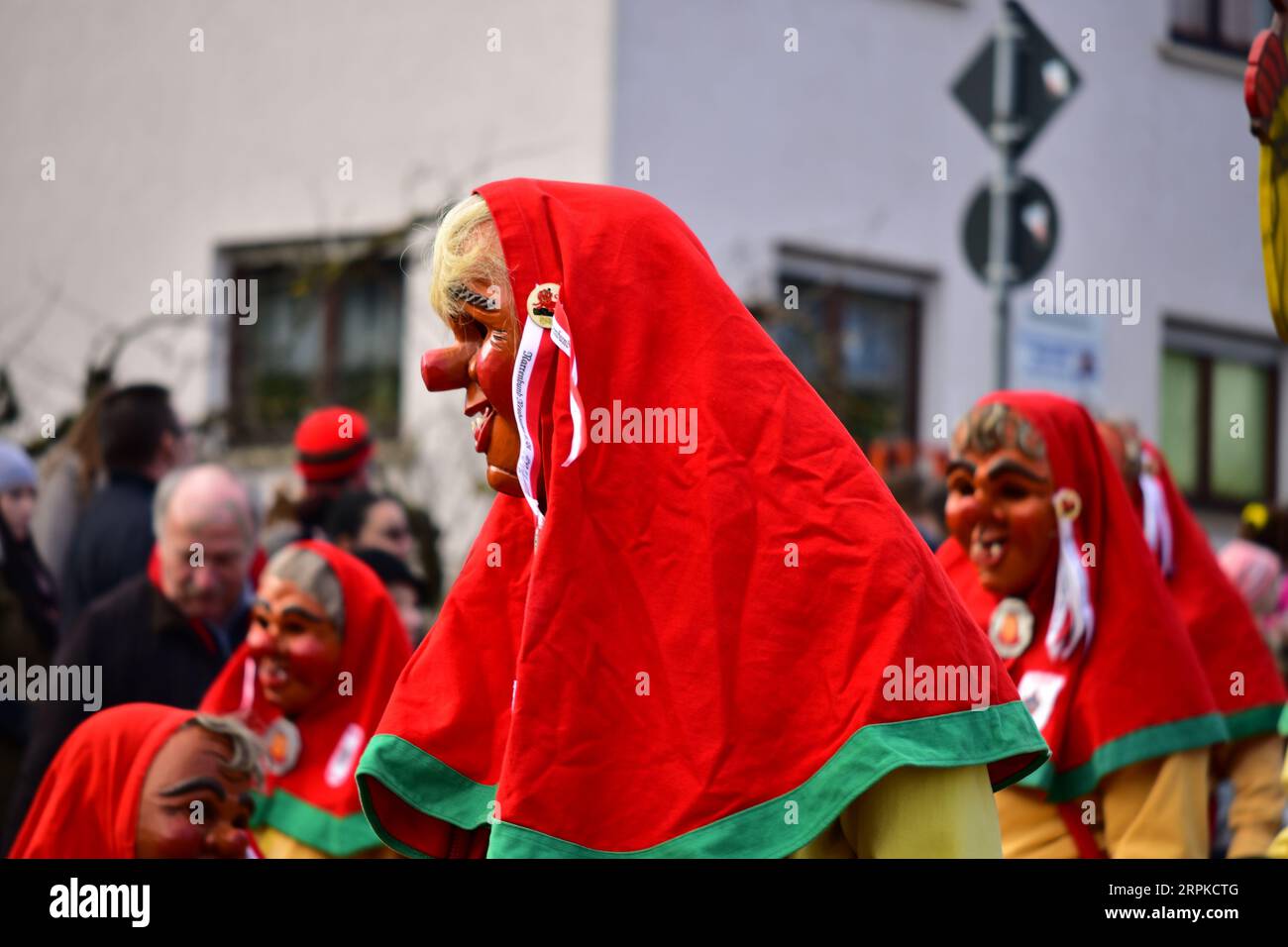 A group of people in festive masks participating in a traditional ...
