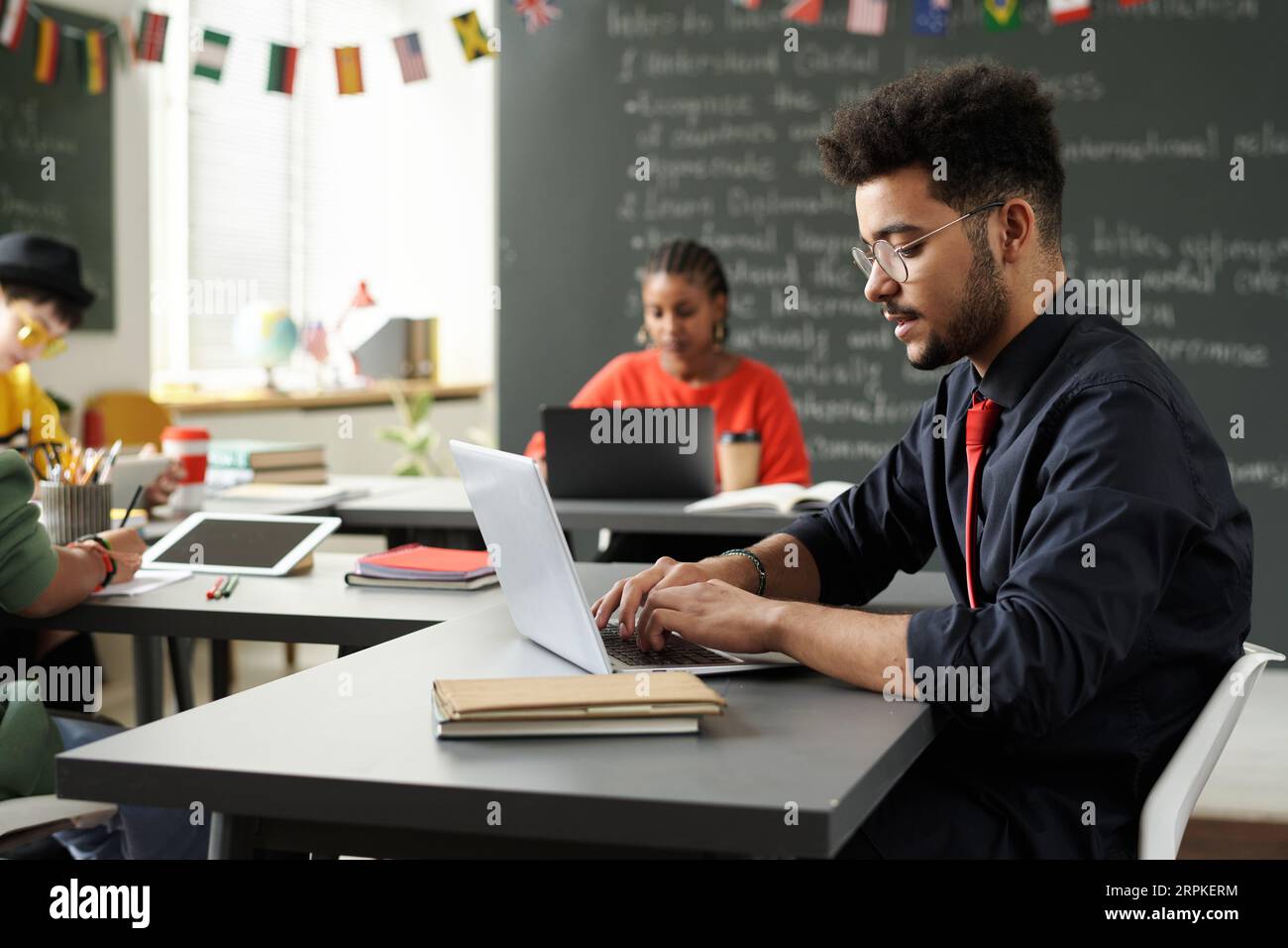 Serious student using laptop while studying in the classroom at school ...
