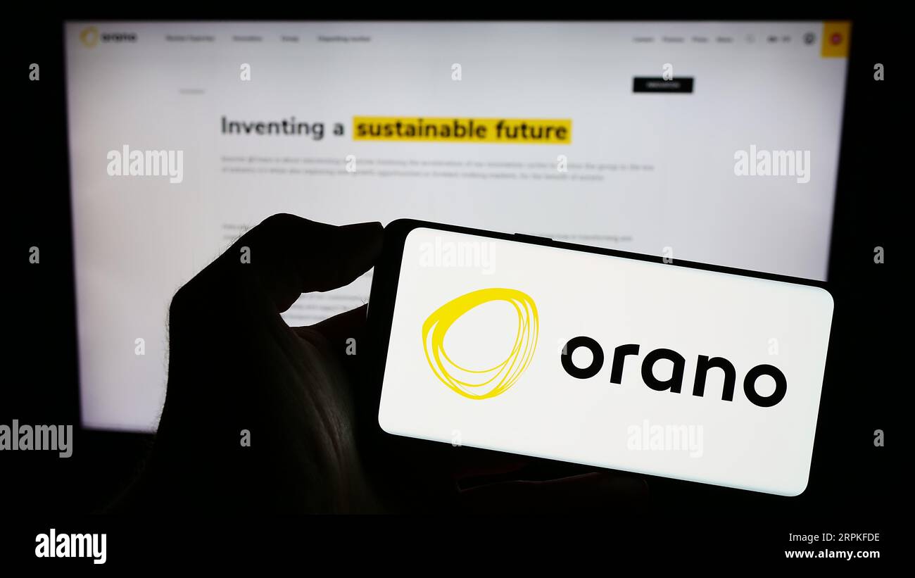 Person holding mobile phone with logo of French nuclear energy company ...