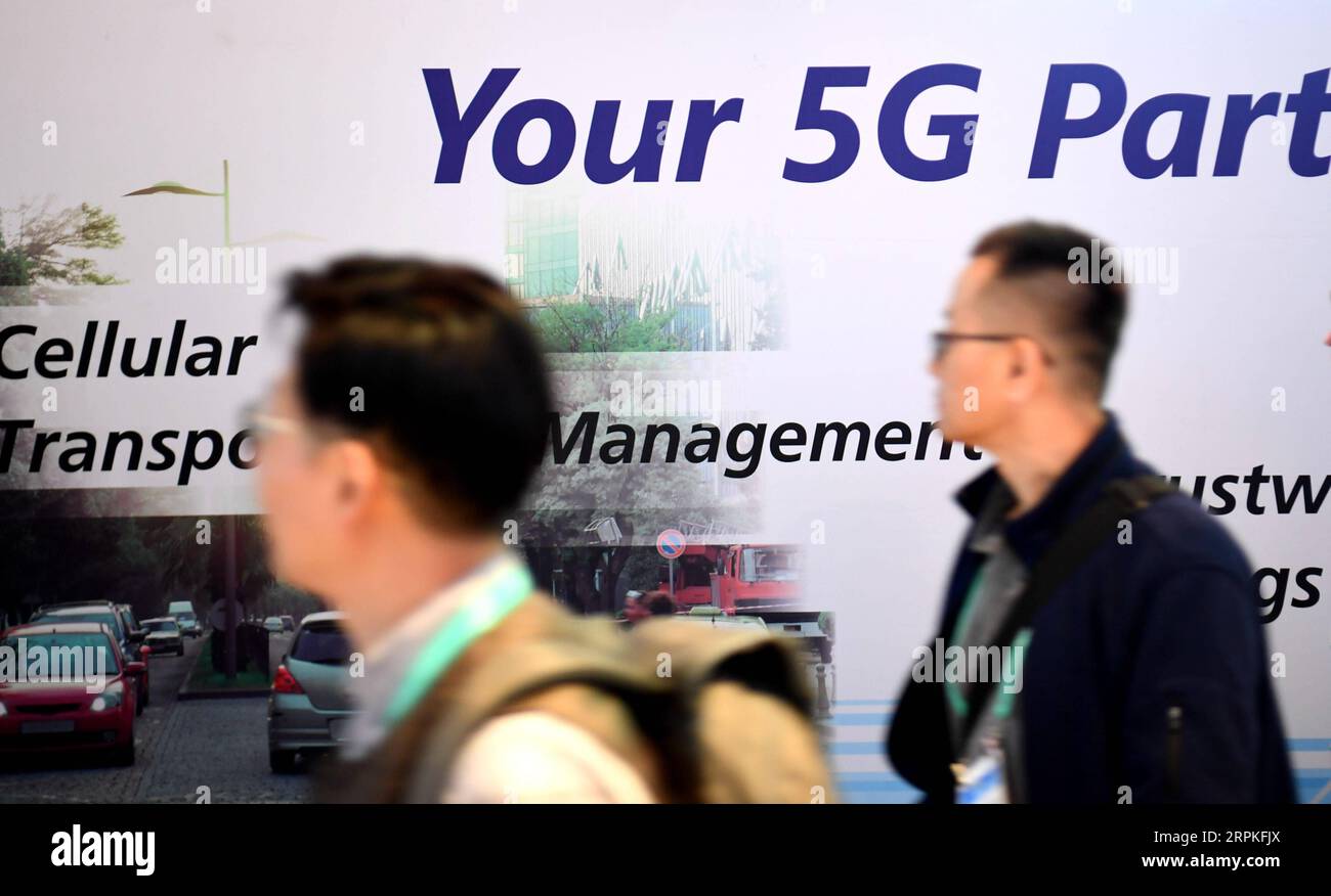 200110 -- LAS VEGAS, Jan. 10, 2020 -- People walk past a 5G poster at the 2020 Consumer ...