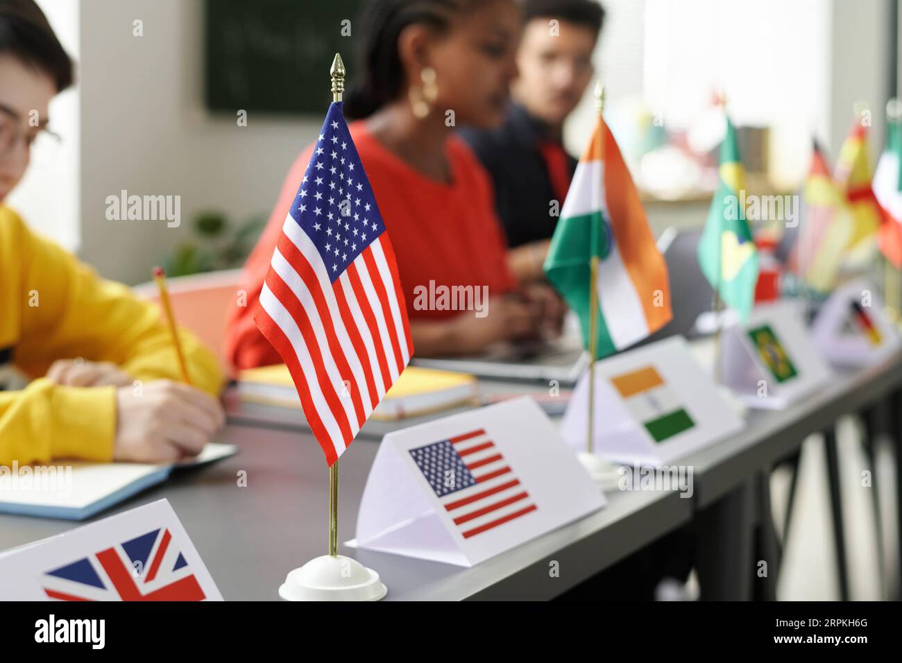 Close-up of flags of different countries standing on table with ...