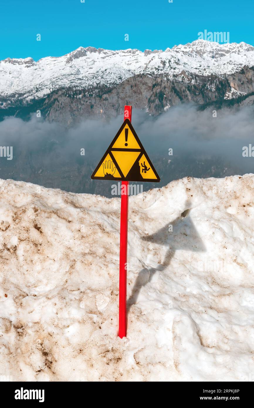 Warning sign at cliff on snow capped mountain in Triglav national park ...