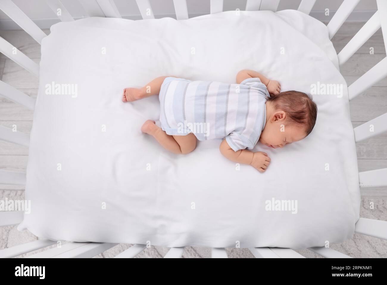 Cute newborn baby sleeping in crib at home, top view. Bedtime Stock ...