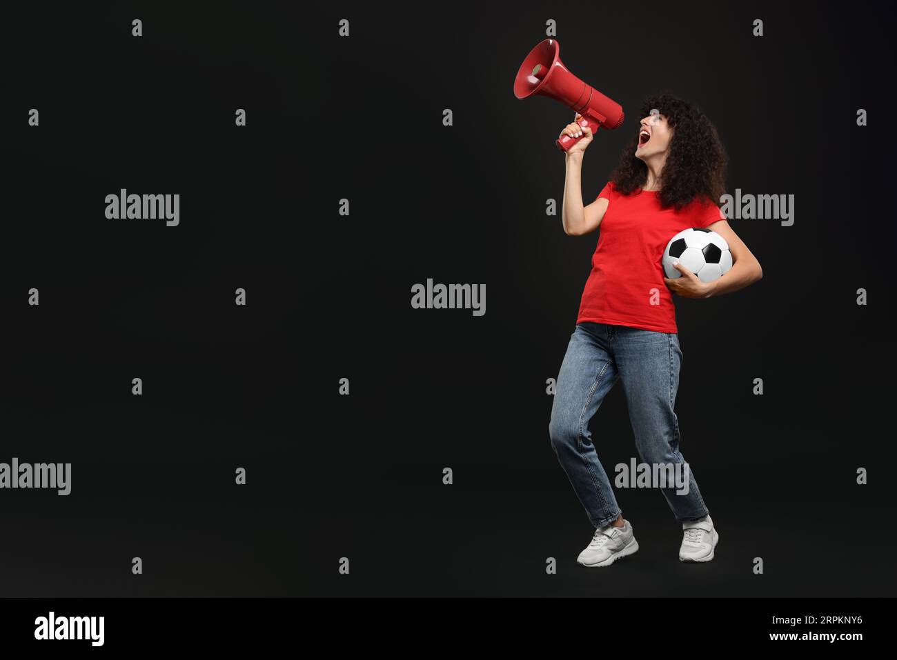 Fan with soccer ball using megaphone on black background, space for ...