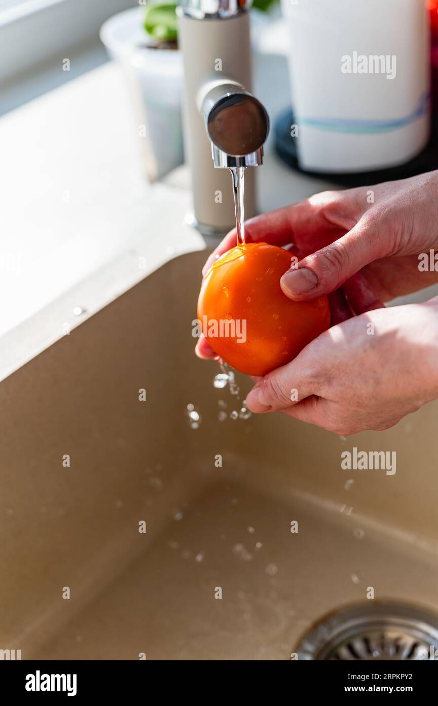 Woman washing fresh vegetables under hi-res stock photography and images - Alamy