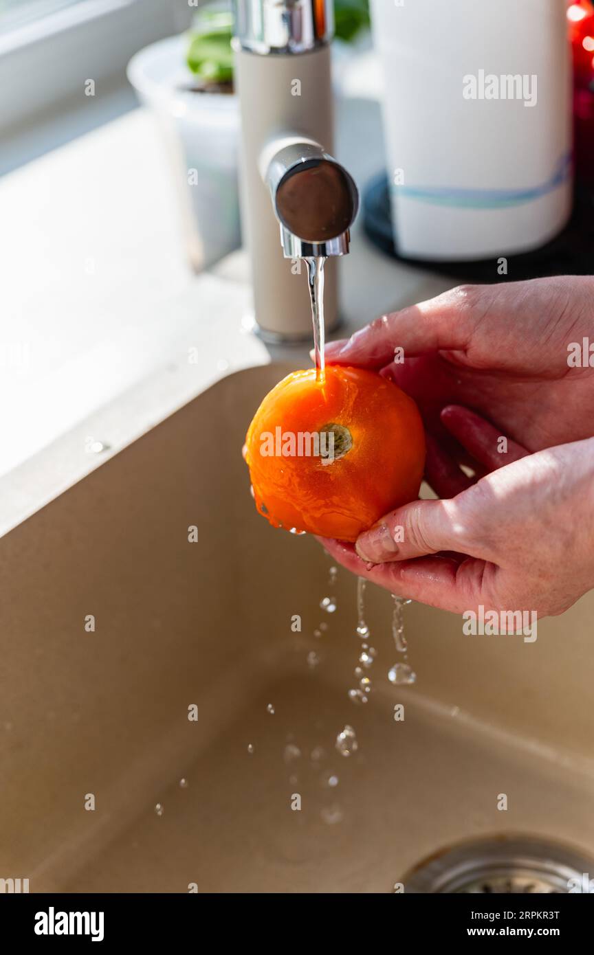 Female washing vegetables under tap hi-res stock photography and images ...