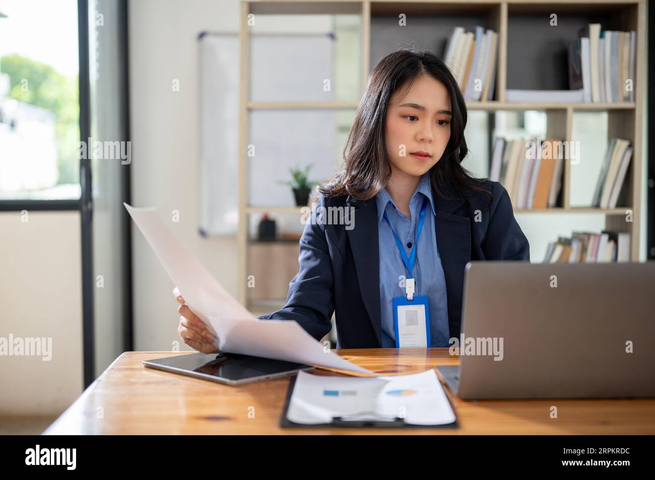 A serious and focused Asian businesswoman or female office worker in a ...