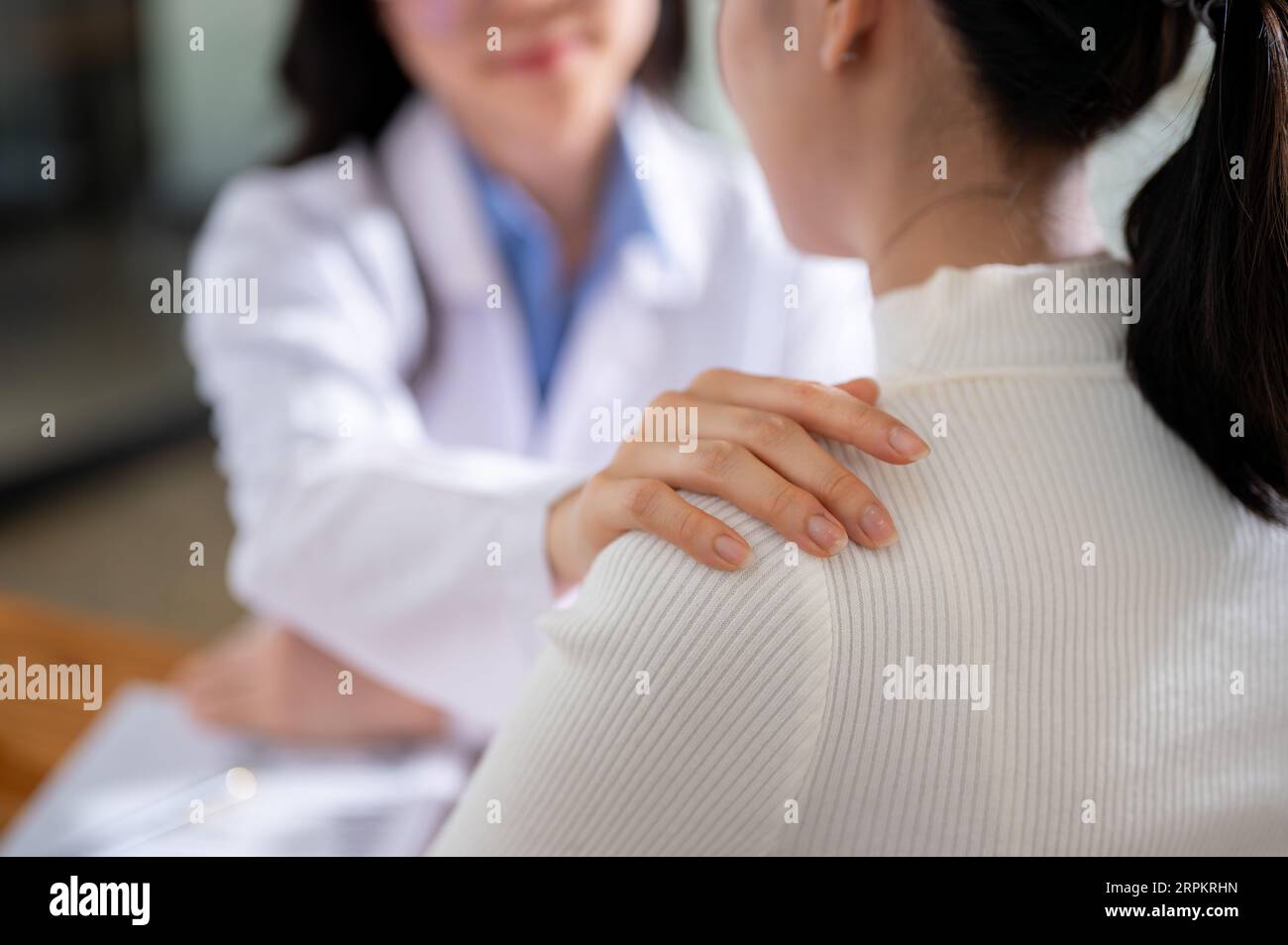Close-up image of a caring female doctor or psychiatrist is touching a ...