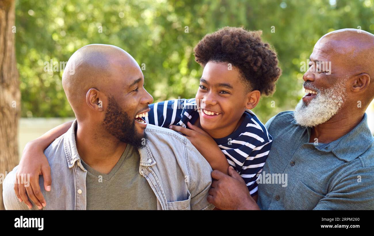 Multi-Generation Male Family Having Fun Playing Outdoors In Garden Park ...