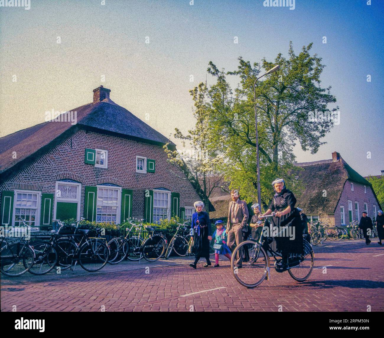 Netherlands, Staphorst, women on their way to church on a bycicle in ...