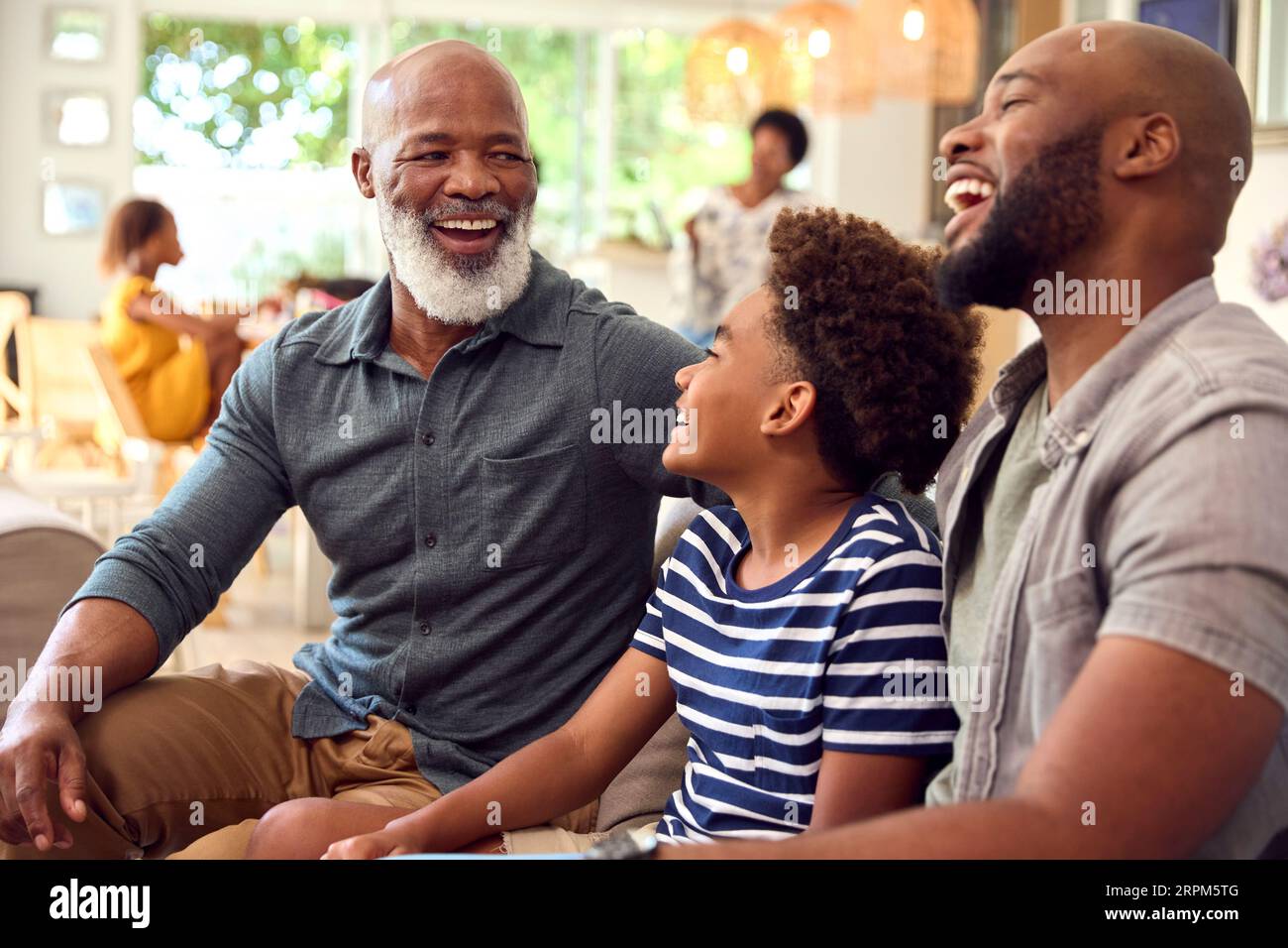 Laughing Multi-Generation Male Family Hanging Out On Sofa At Home ...