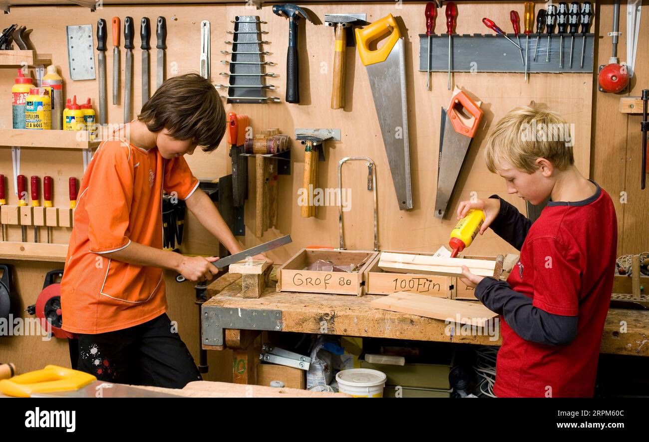 Netherlands; children work with tools and wood during crafts class ...