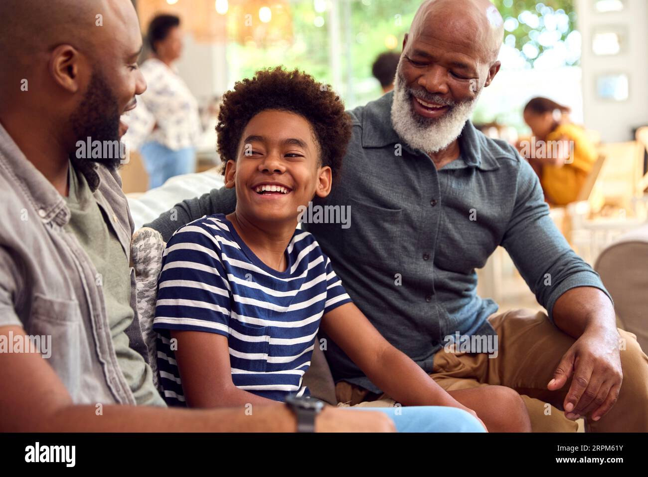 Laughing Multi-Generation Male Family Hanging Out On Sofa At Home Talking Together Stock Photo ...