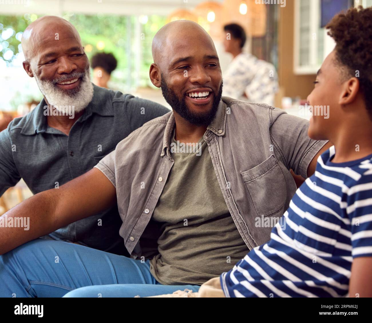 Laughing Multi-Generation Male Family Hanging Out On Sofa At Home ...