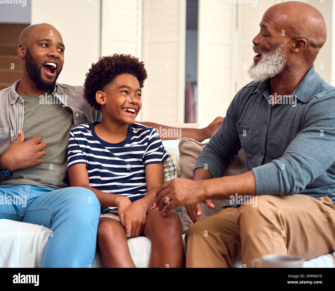 Laughing Multi-Generation Male Family Hanging Out On Sofa At Home ...