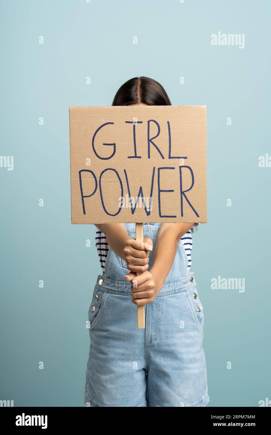 Anonymous woman holding banner GIRL POWER slogan isolated on studio ...